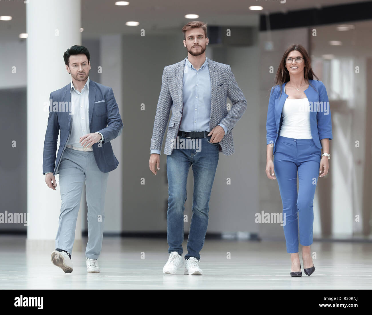 successful employees walk in the office hall Stock Photo - Alamy