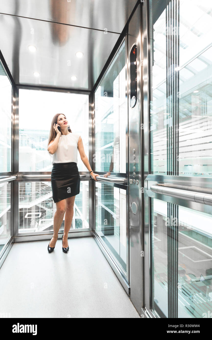 successful and young businesswoman in the elevator business center ...