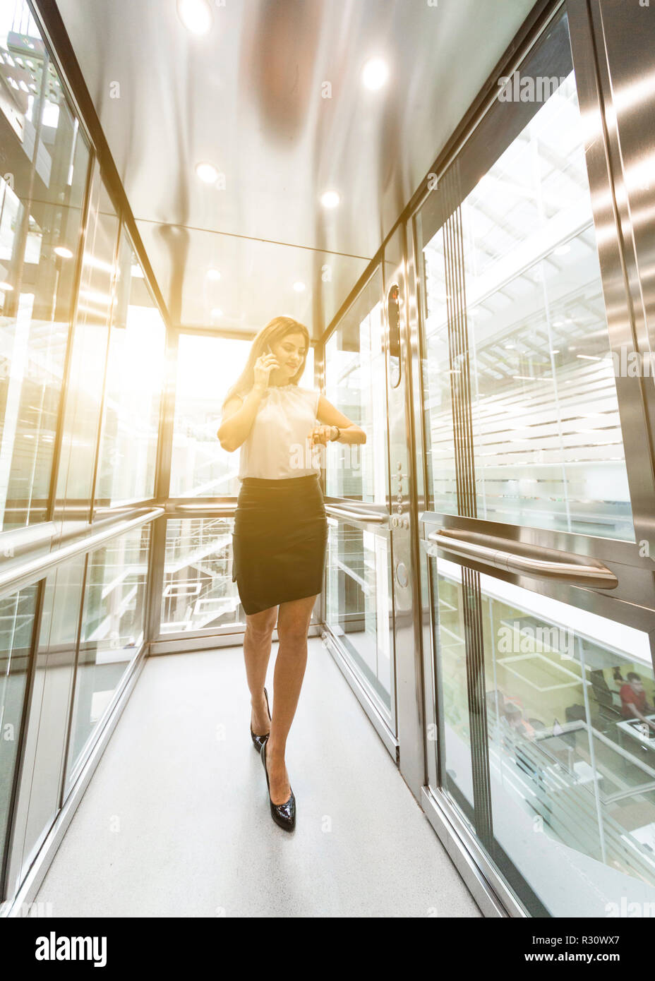 successful and young businesswoman in the elevator business center ...