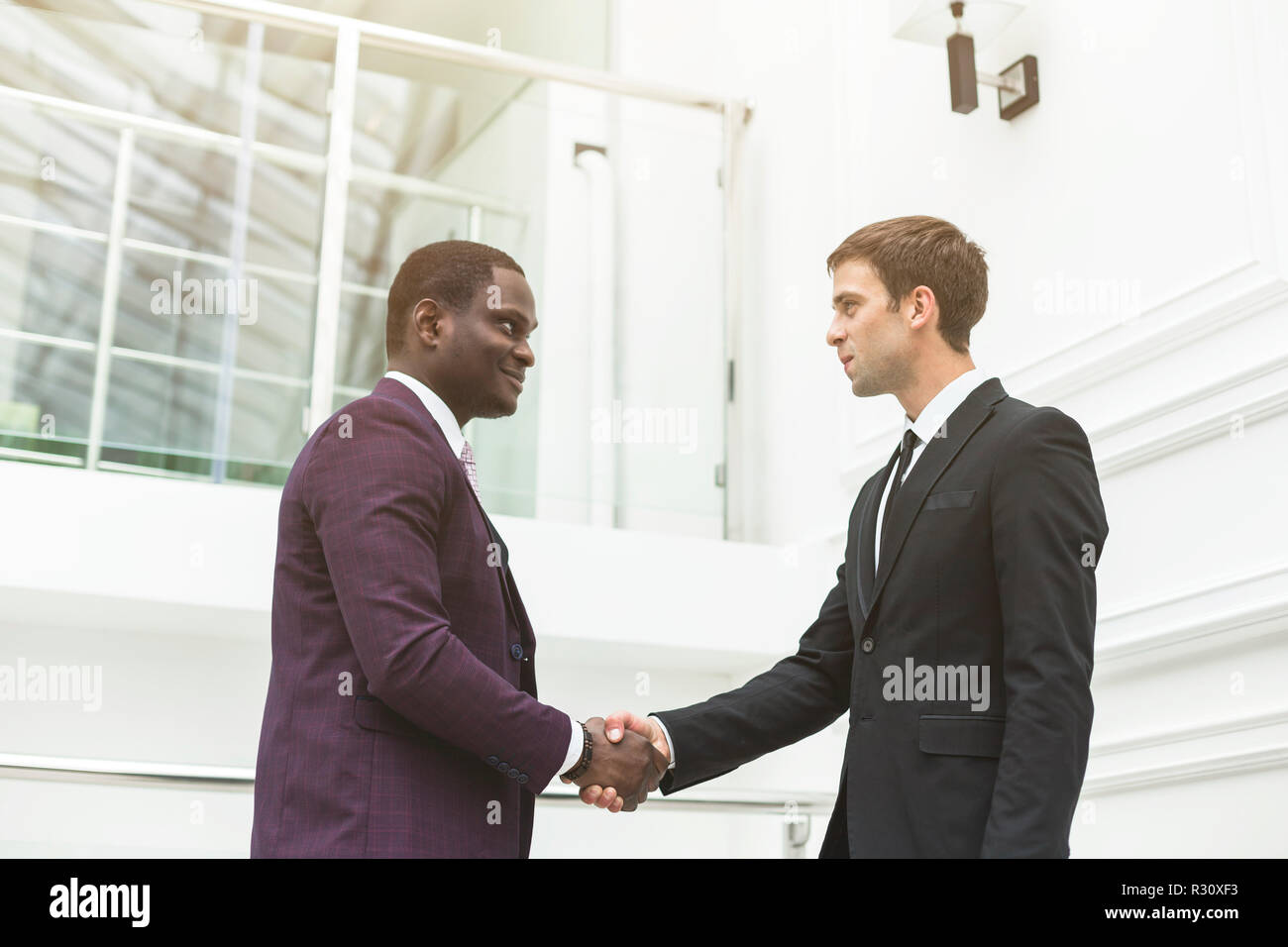 two young businessmen shake hands Stock Photo - Alamy