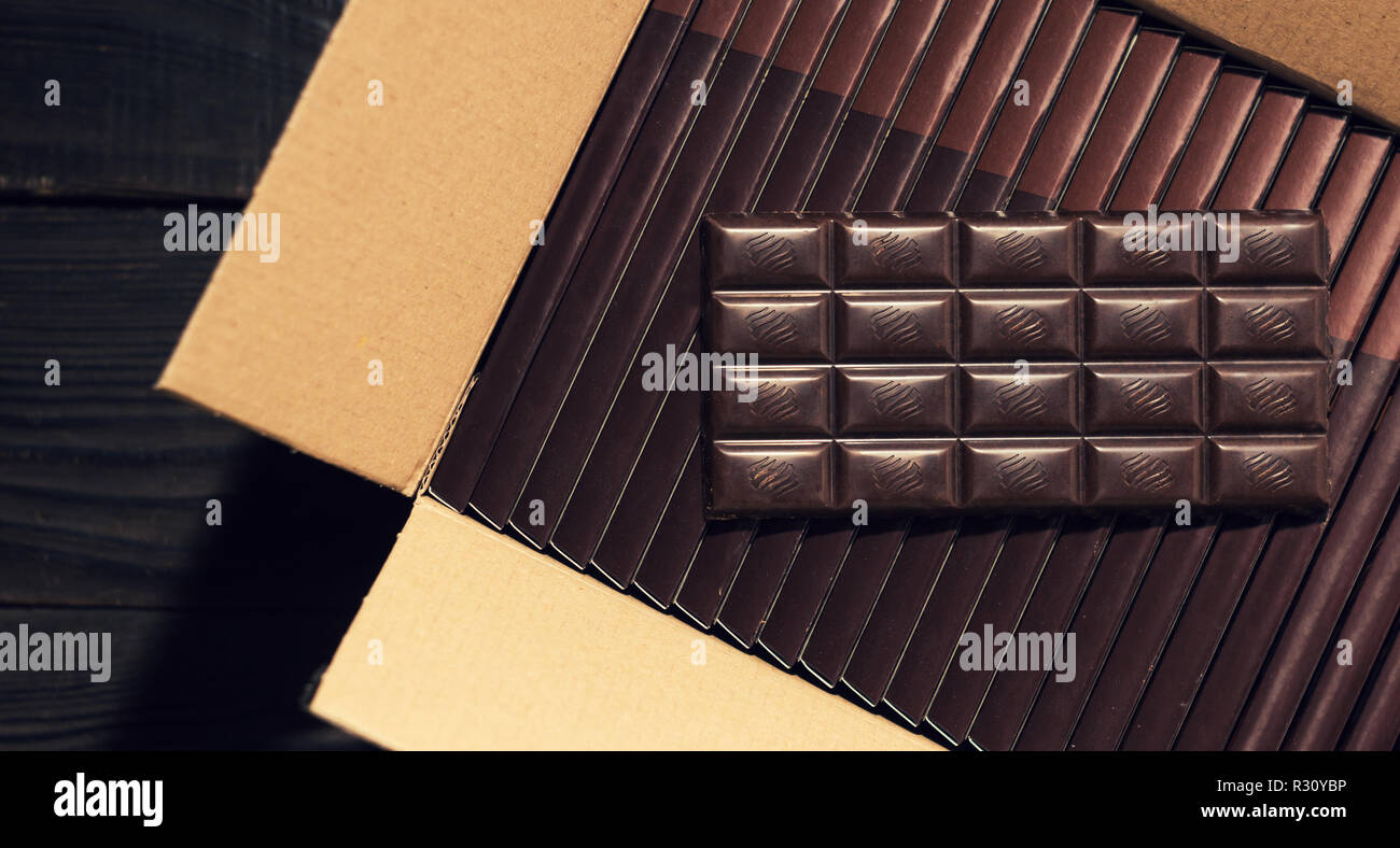 Tiles of dark chocolate on a cardboard box packed with chocolate. Top ...
