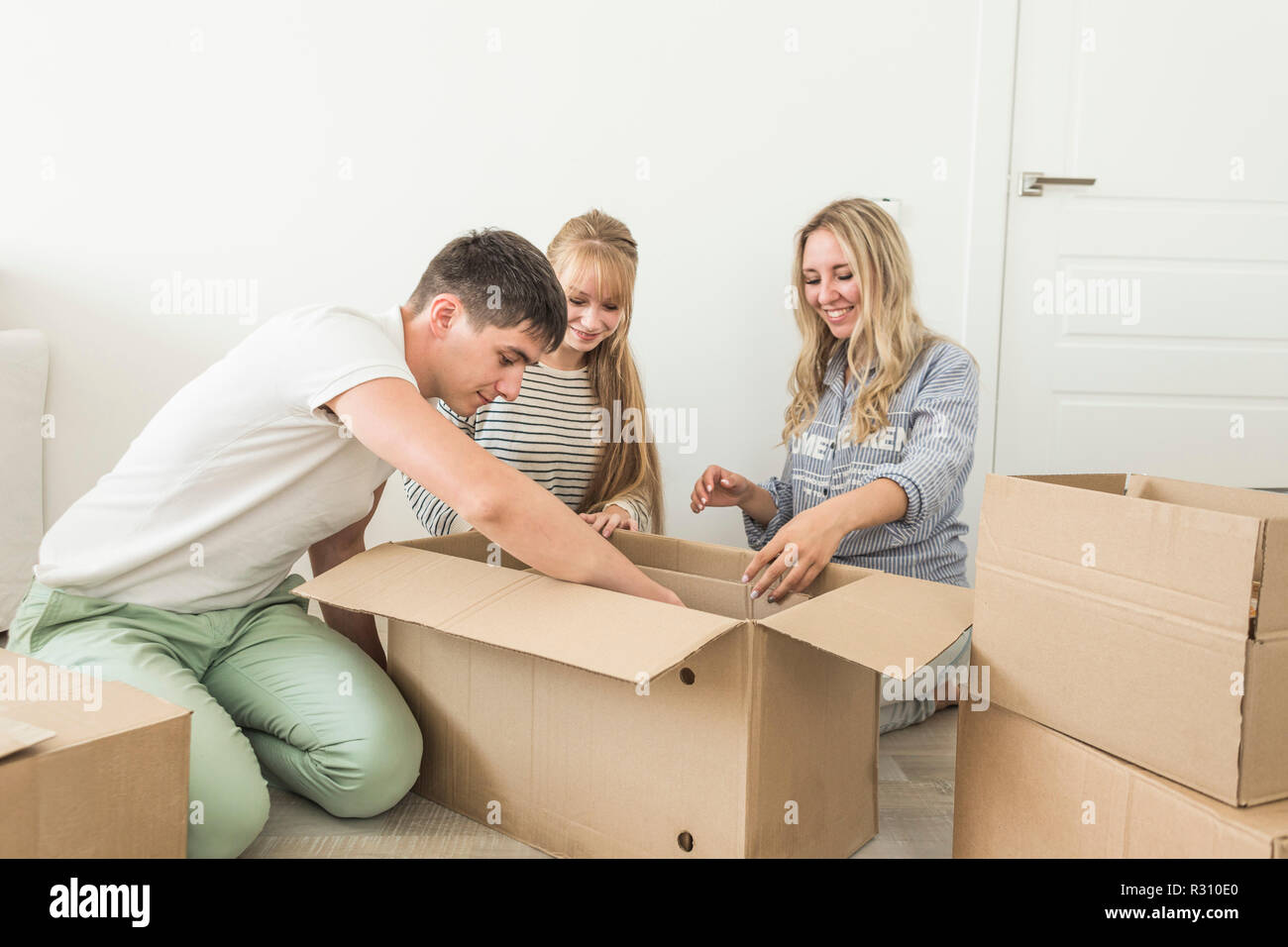 Family unpacking cardboard boxes at new home. moving to a new house ...