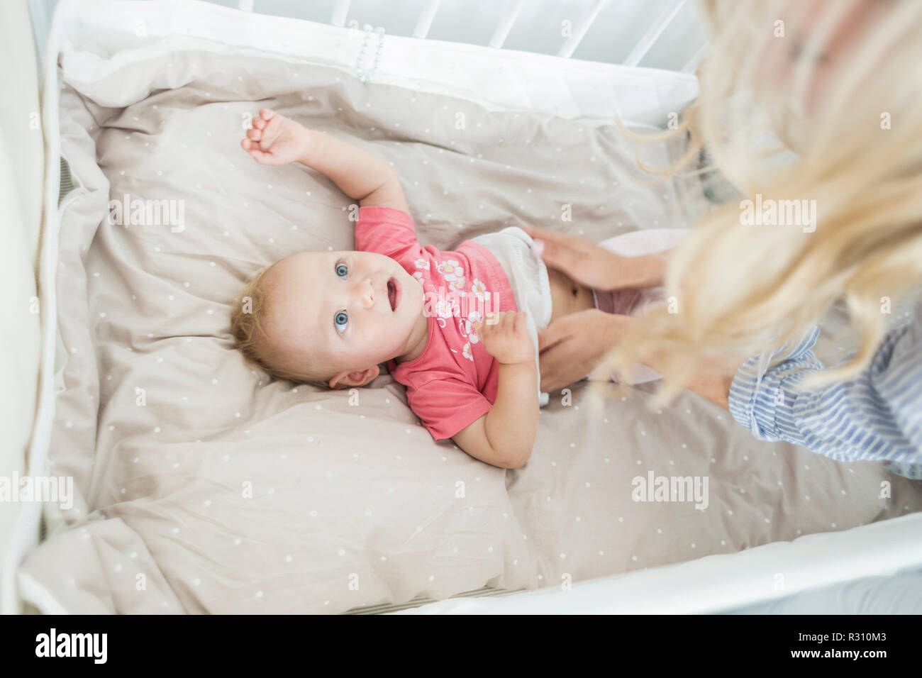 young happy family father and mother and little baby near a lullaby ...