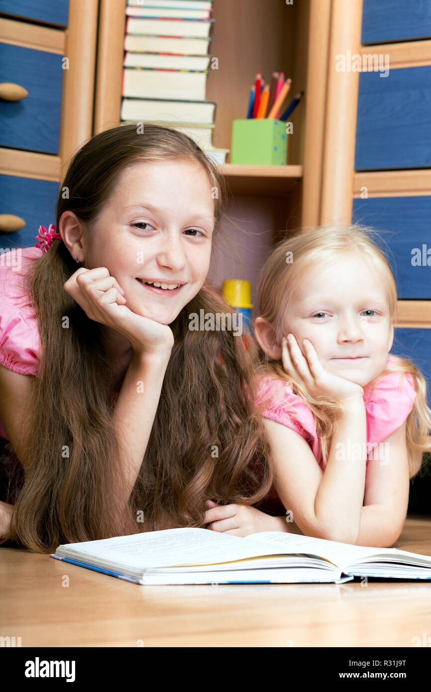 two girls reads book in your room Stock Photo - Alamy