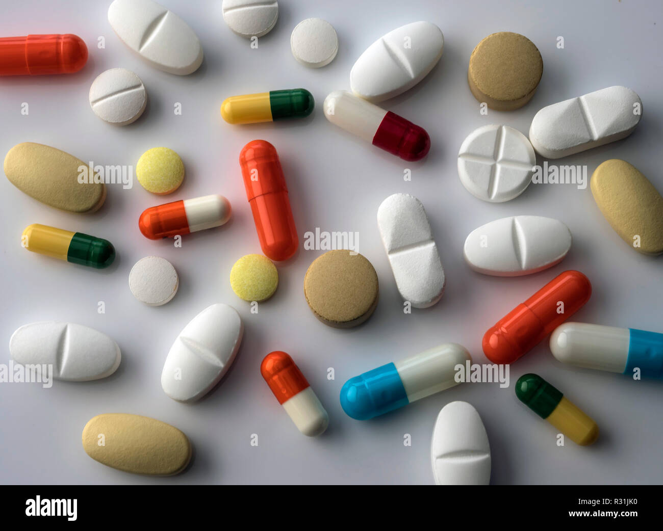Tablets and capsules of different size and color, conceptual image ...