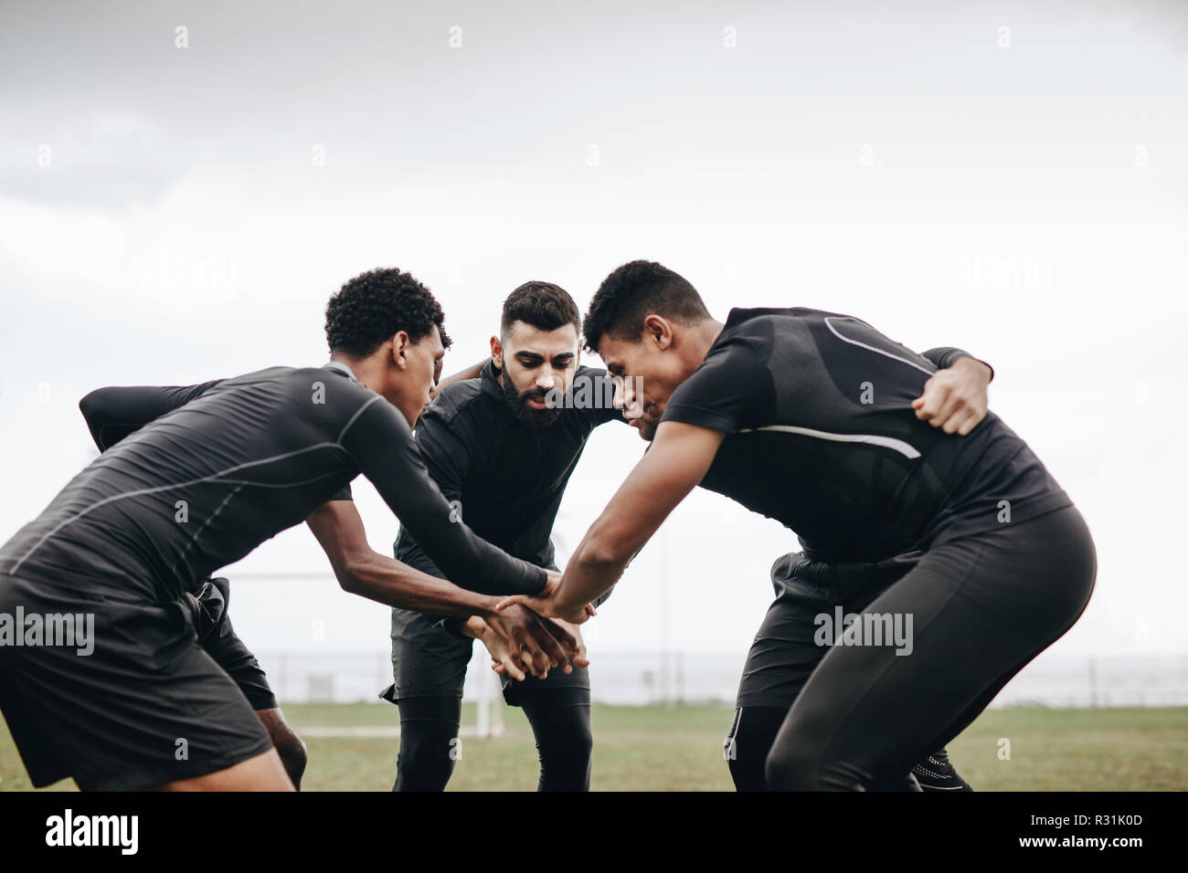 Soccer players discussing game strategy standing in a huddle on the ...