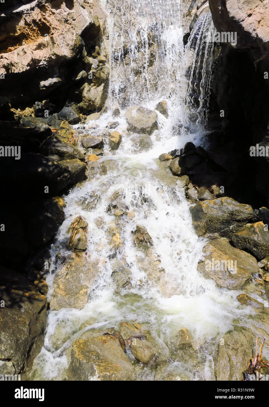 Water frozen in time over golden rocks Stock Photo - Alamy