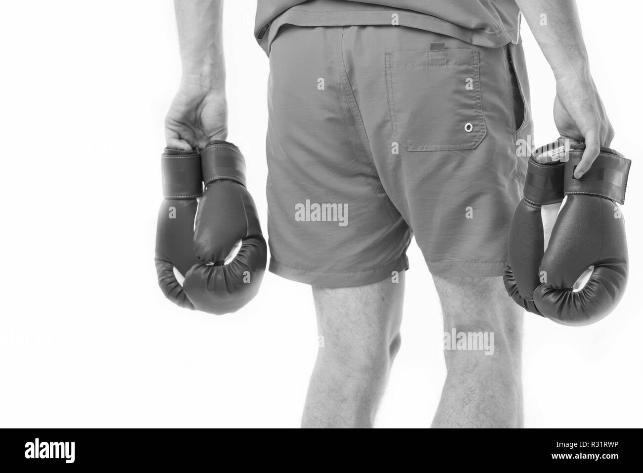 Looking for opponent. Man in shorts carries two pairs boxing gloves ...