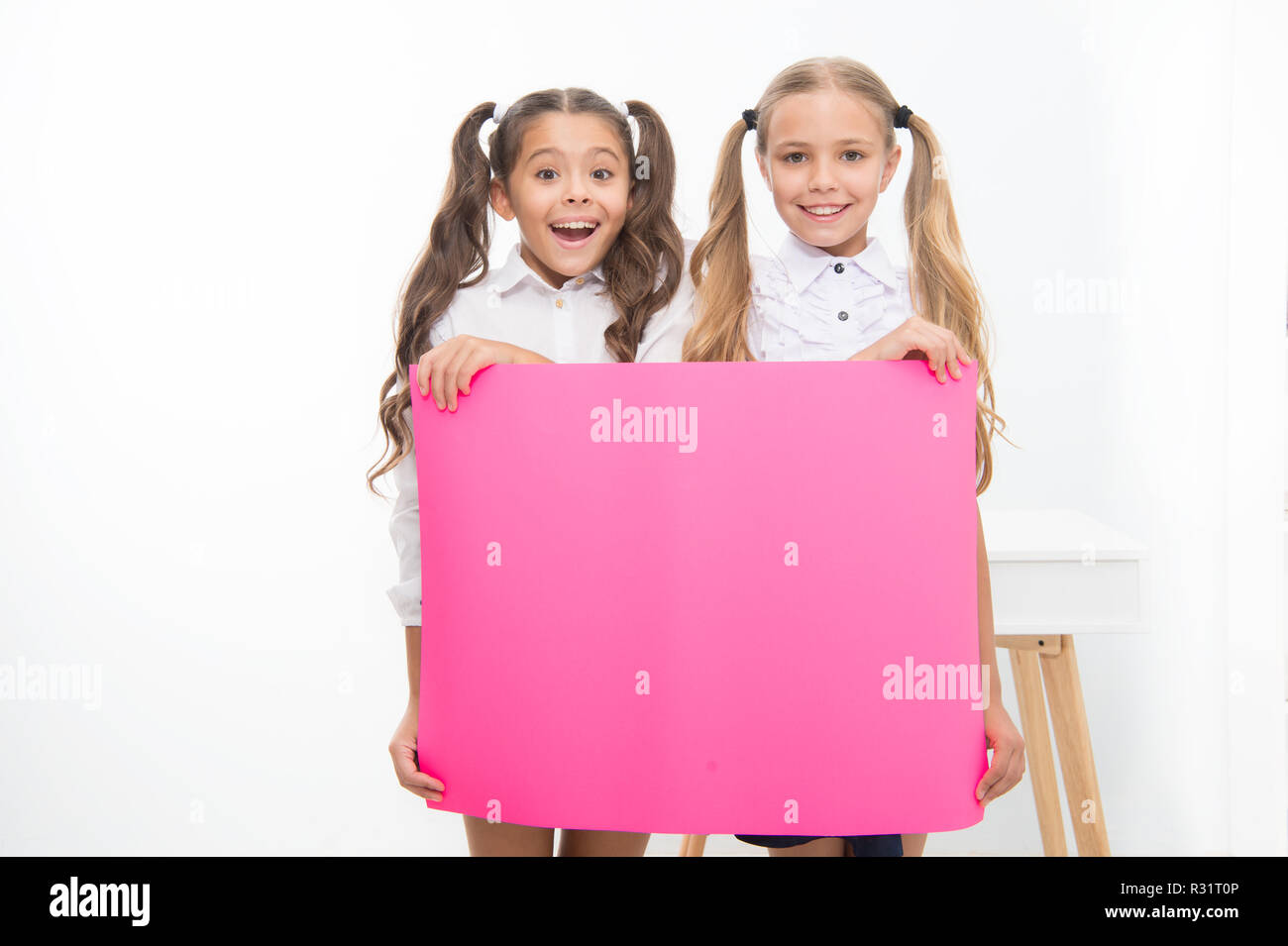 Schoolgirls hold advertisement poster copy space. Children hold ...