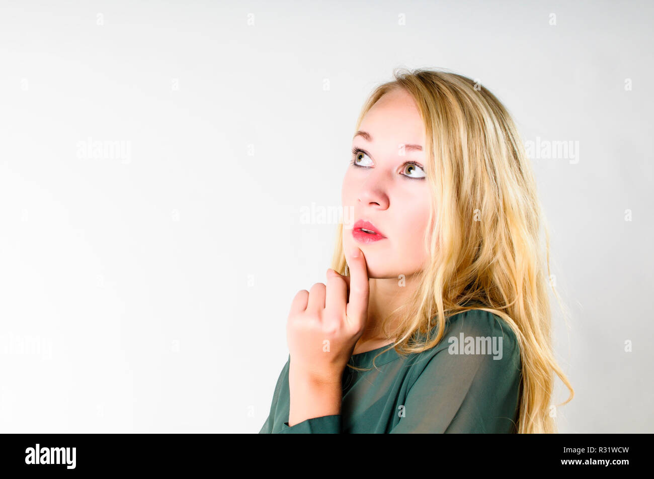 young woman looks thoughtful Stock Photo - Alamy