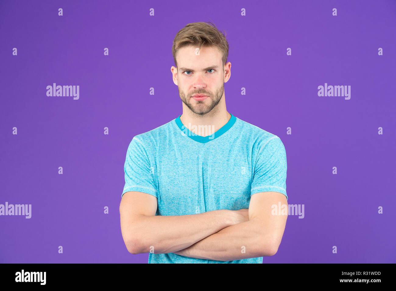 Strong and muscular. Man strict handsome unshaven guy on violet ...