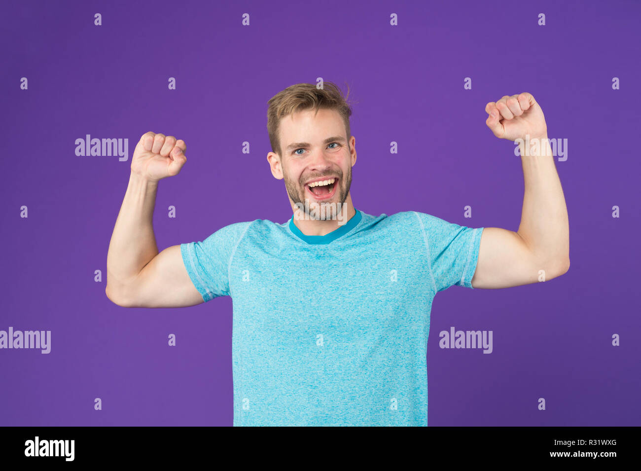 Strong and full of energy. Man strong handsome unshaven guy on violet ...