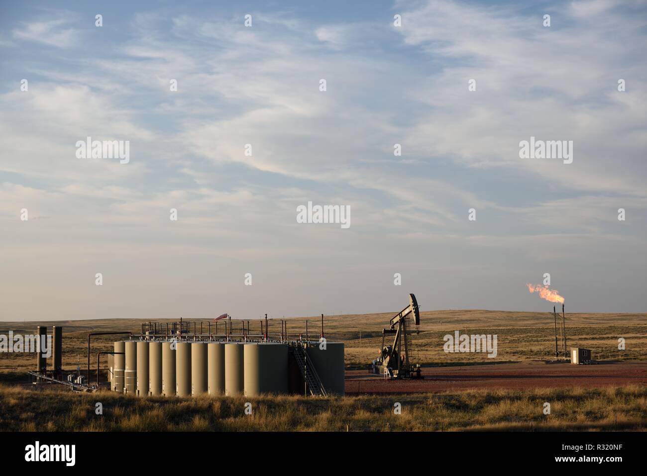 Crude oil well site, production holding tanks, pump jack, and natural gas flaring in the Powder ...