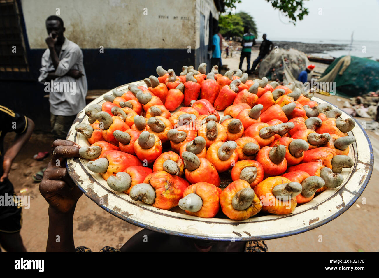 SIERRA LEONE, Tombo , street vendor sells cashew nut and fruit on plate ...