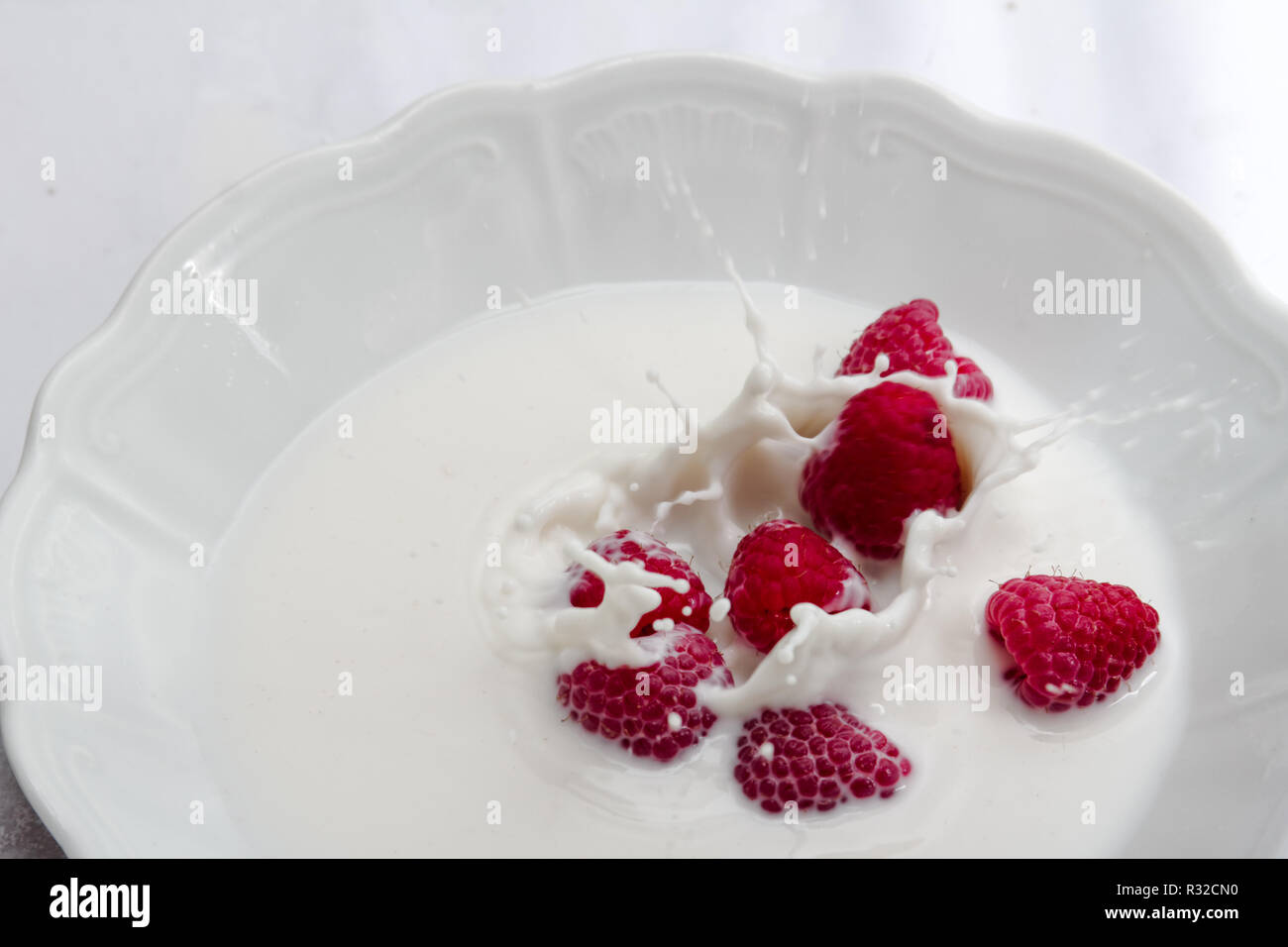 raspberry falls into milk 3 Stock Photo - Alamy