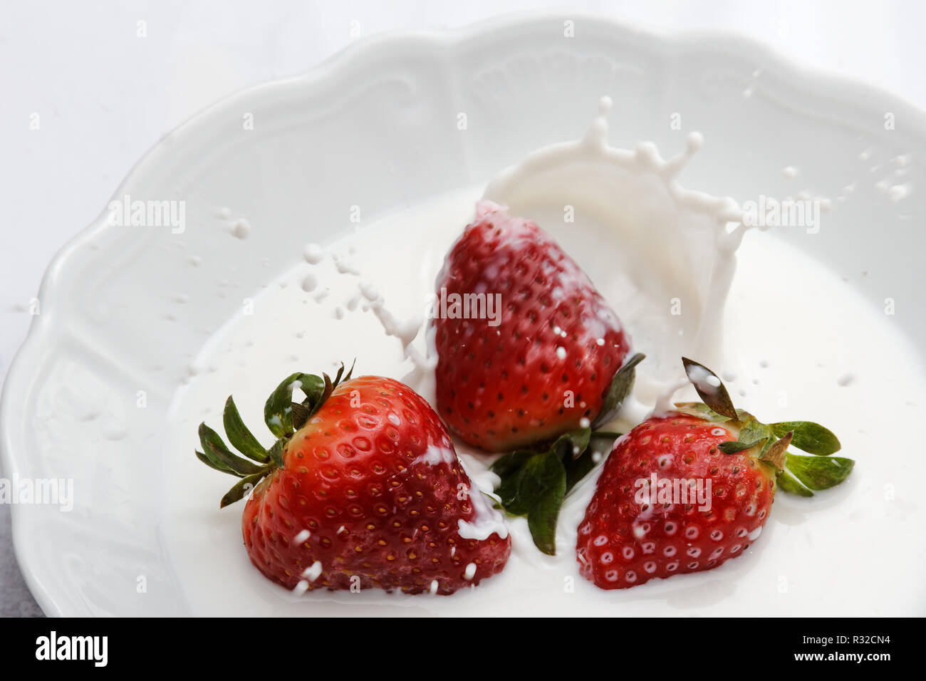 strawberry falling into milk 4 Stock Photo - Alamy