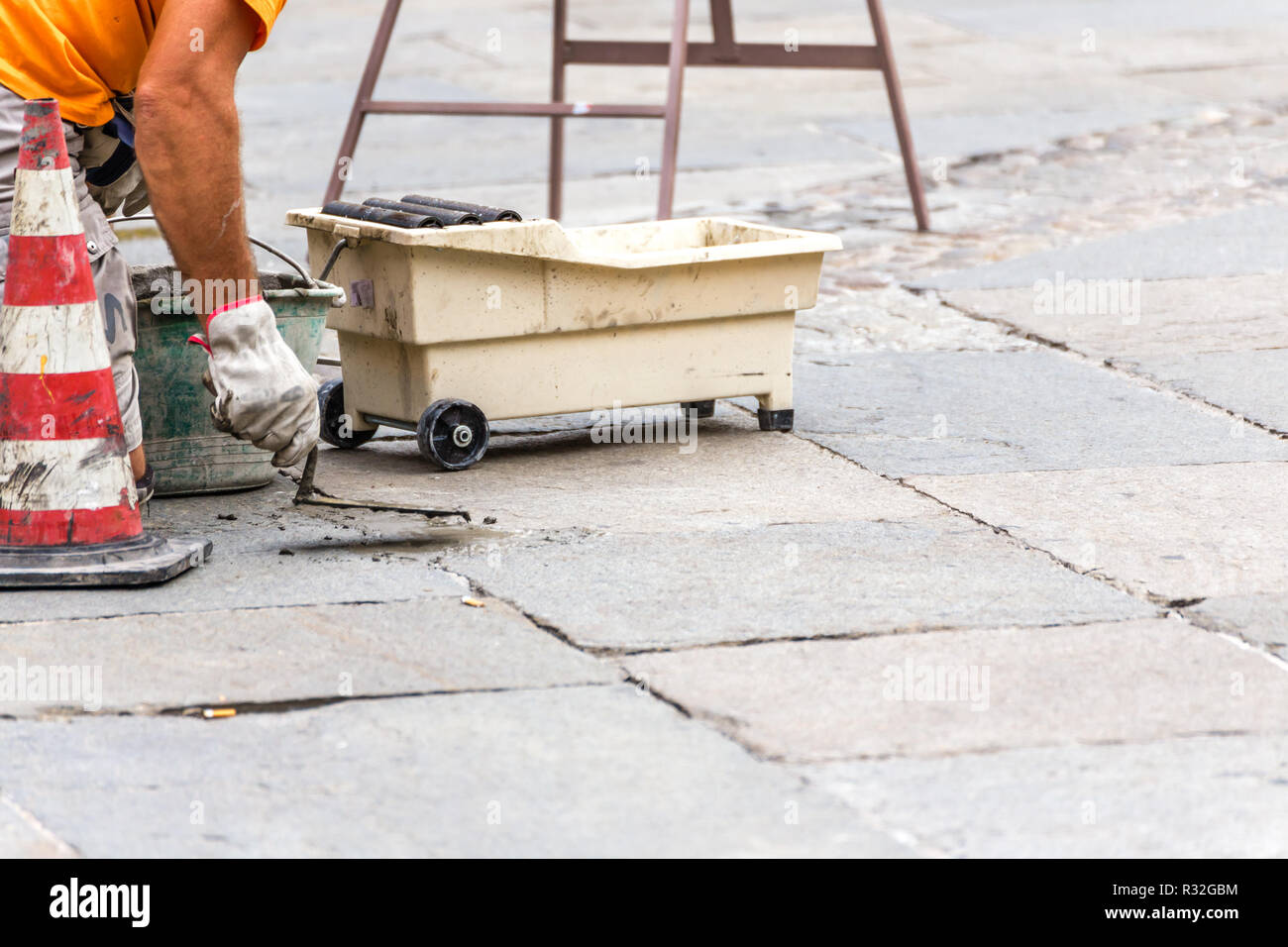 bricklayer repairing cobbled floor in urban square Stock Photo - Alamy