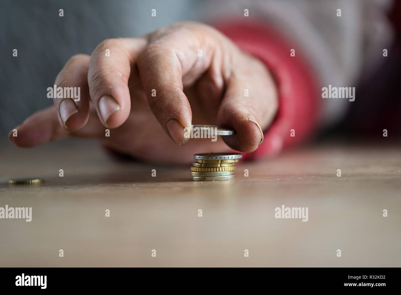 Closeup of hand of a homeless man with dirty nails making stack of Euro ...