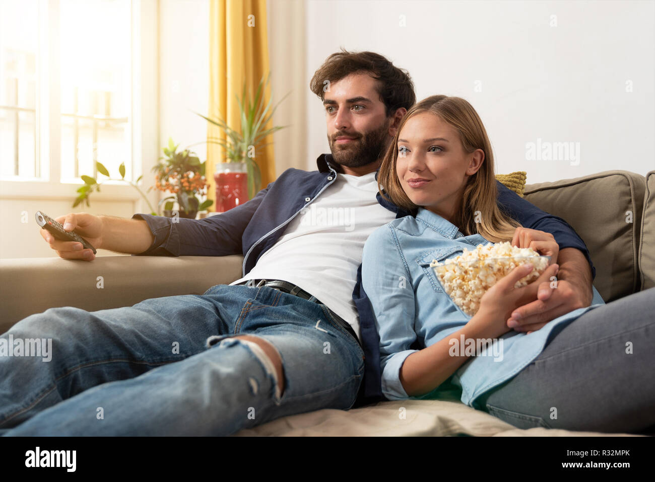 Couple eating popcorn on sofa hi-res stock photography and images - Alamy