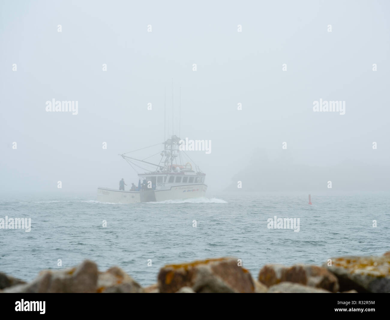 A lone lobster boat returns to port at Cape Forchu, Nova Scotia, Canada ...