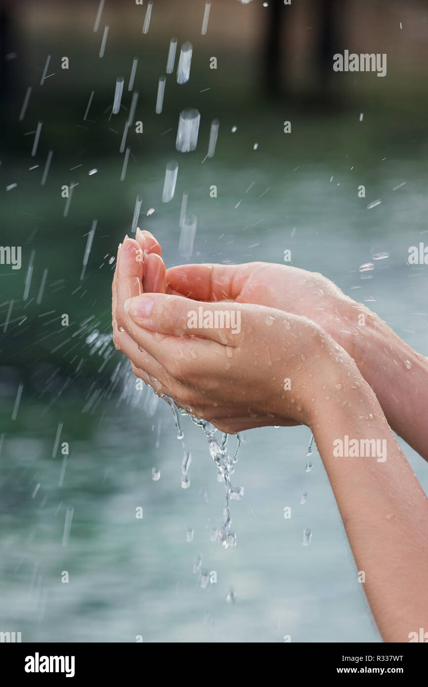 Crop woman catching water drops Stock Photo - Alamy