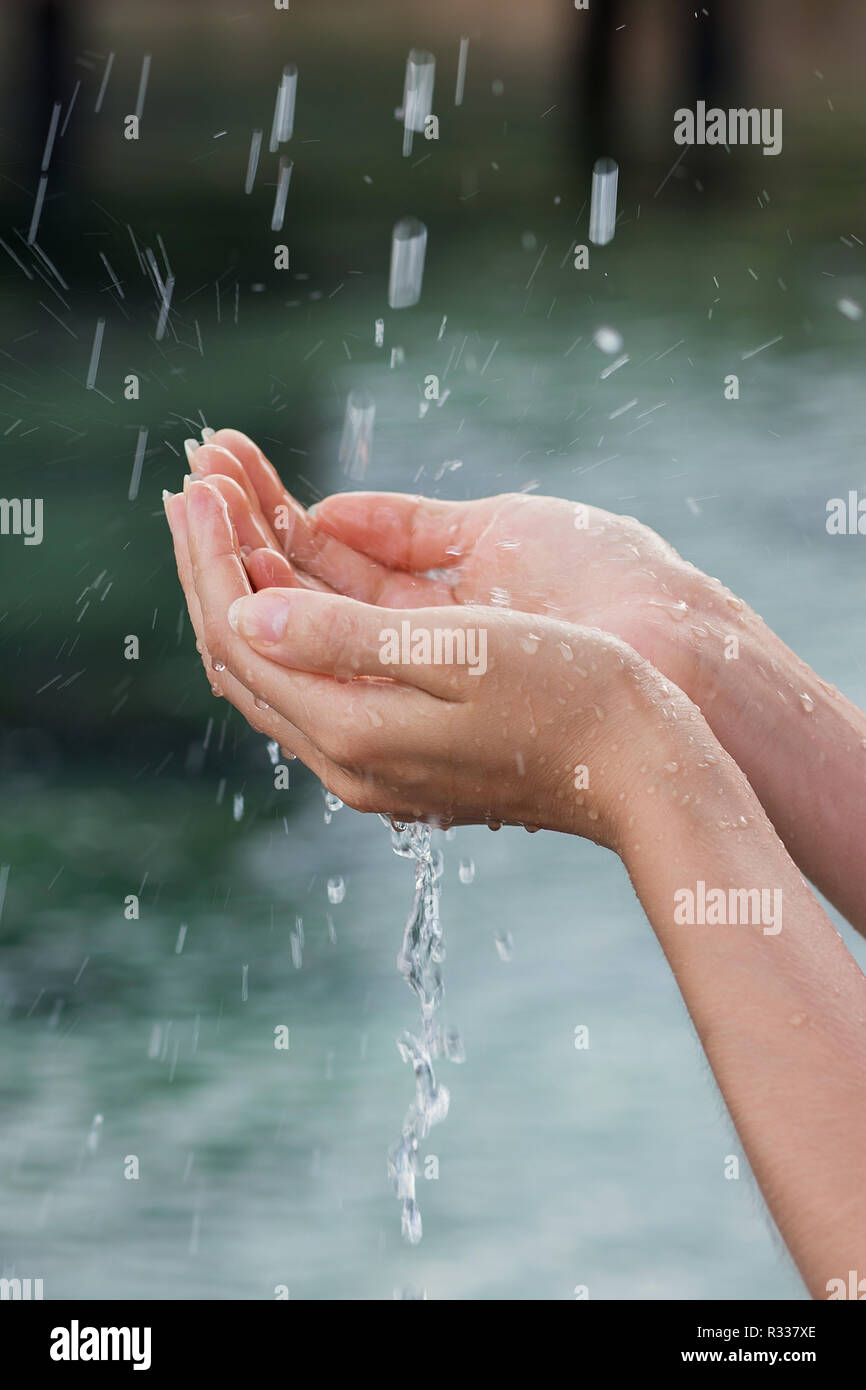 Crop woman catching water drops Stock Photo - Alamy