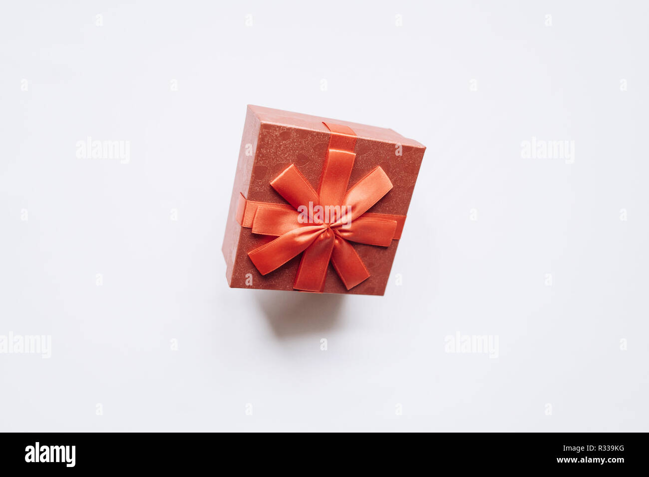 Red box with a bow with a gift on a white background Stock Photo - Alamy