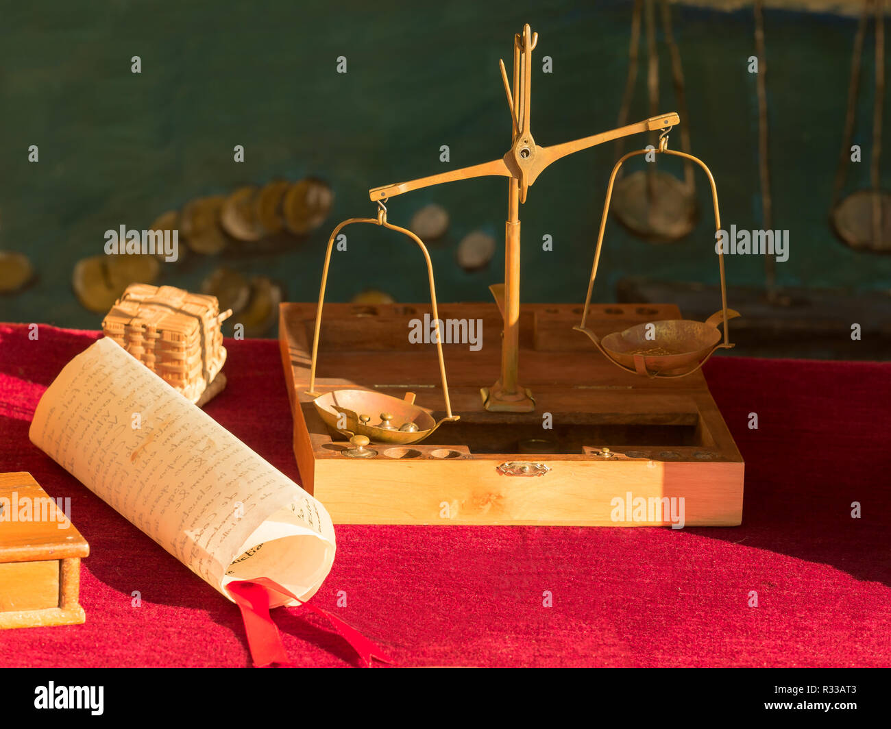 ancient weighing scale (balance) made in brass on a red tablecloth ...