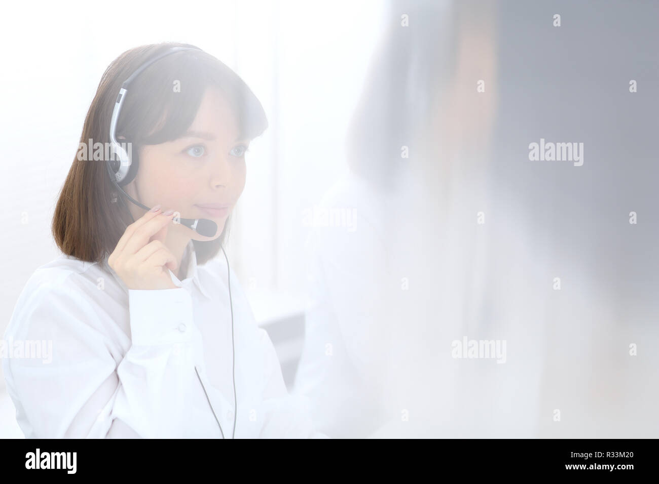 Call center. Group of operators at work. Focus on young brunette woman. Business concept Stock ...