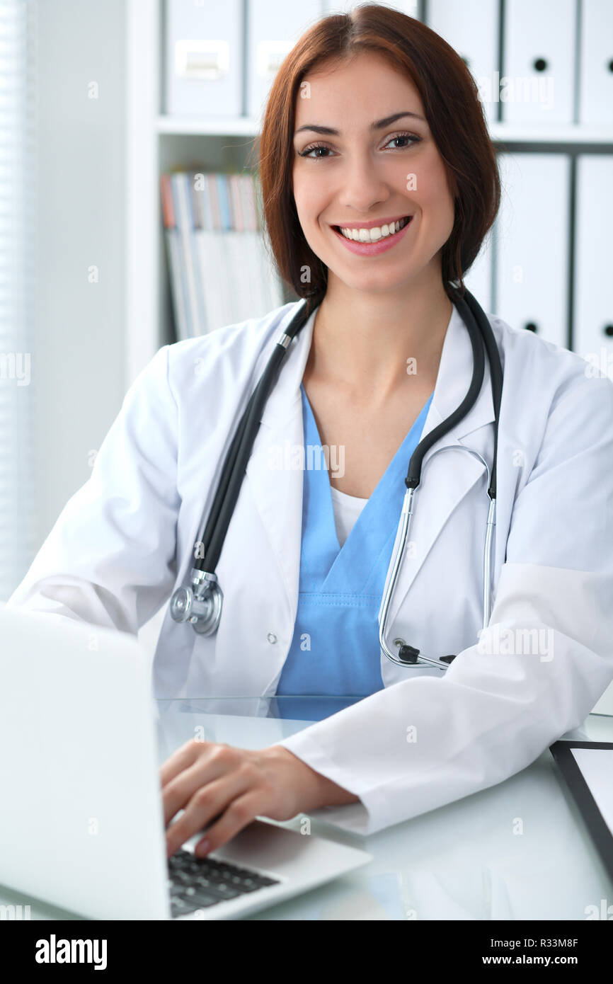 Doctor woman at work. Physician typing on laptop computer. Medicine ...
