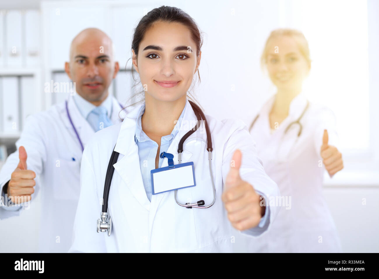 Group of doctors showing OK or approval sign with thumb up. High level ...