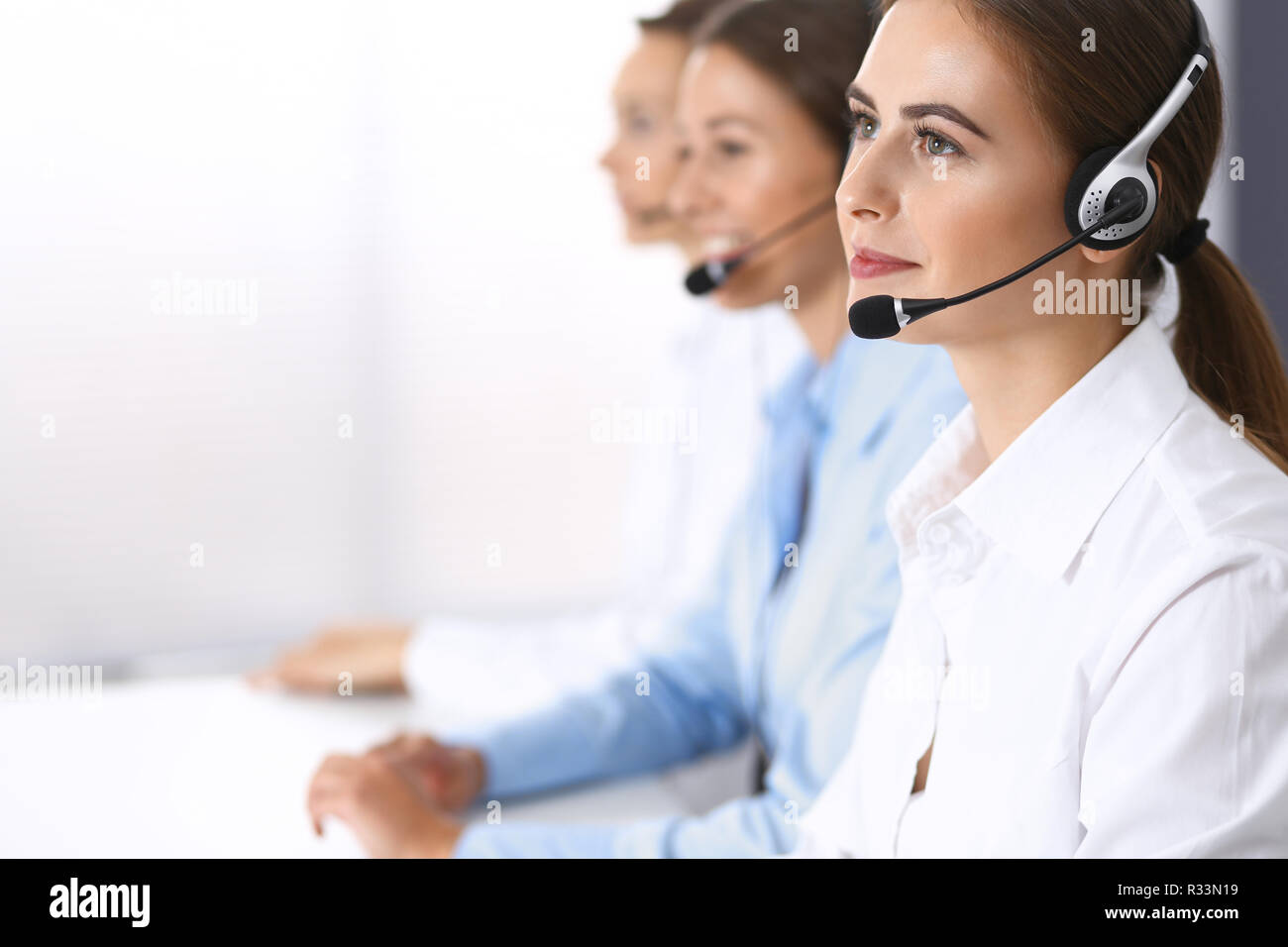 Call center. Group of operators at work. Focus at beautiful business woman in headset Stock ...