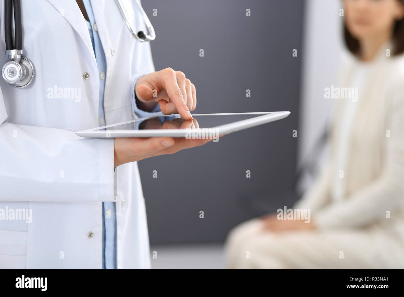 Female doctor woman using digital tablet while standing near reception ...
