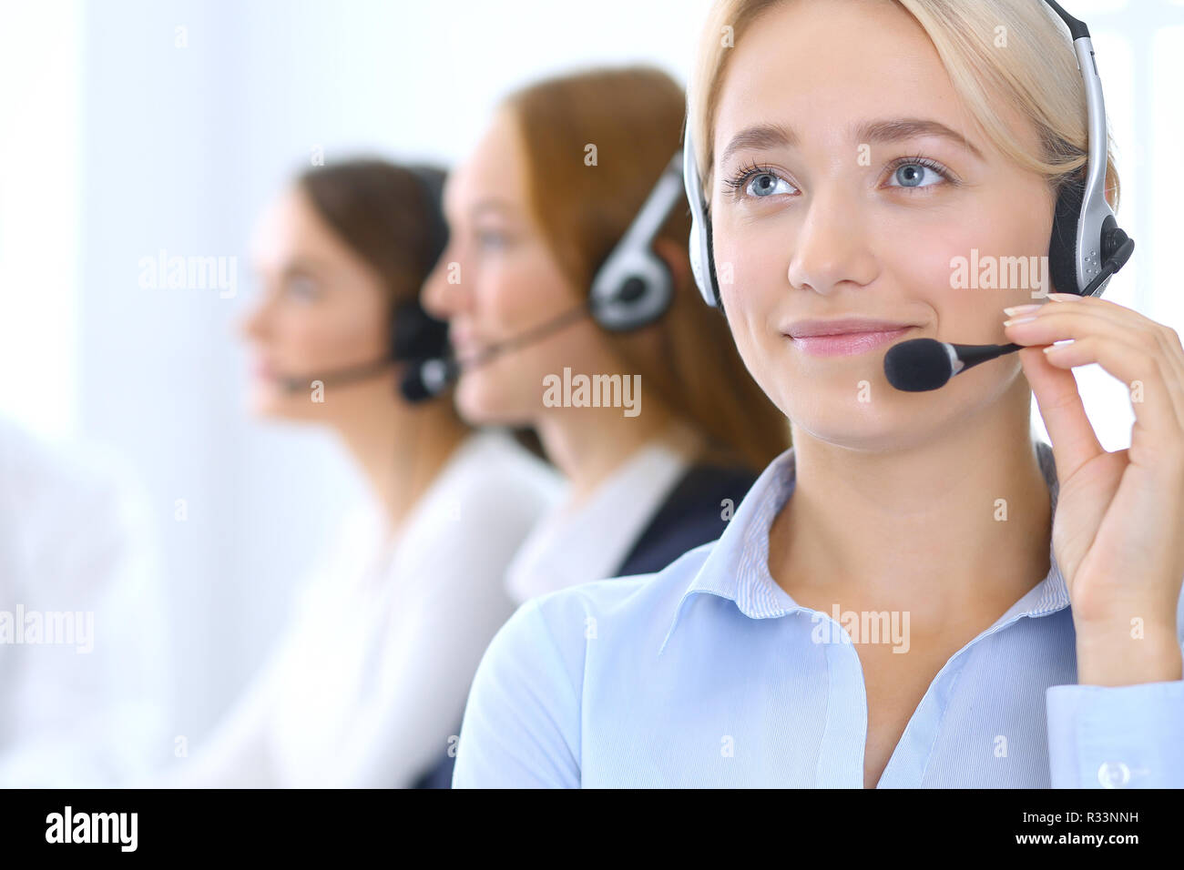 Call center. Group of operators at work. Focus at blonde business woman ...