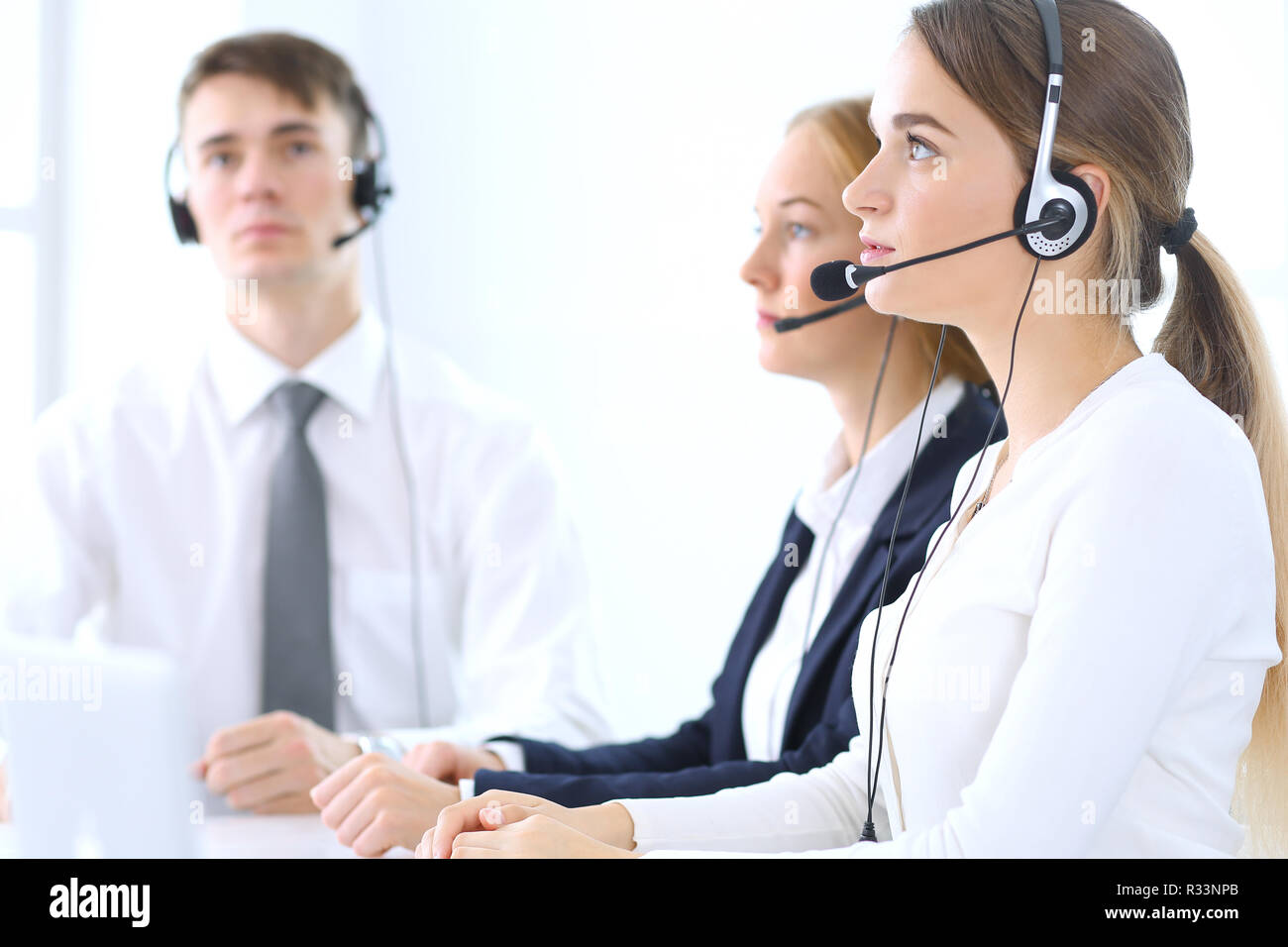 Call center. Group of operators at work. Focus at brunette business ...