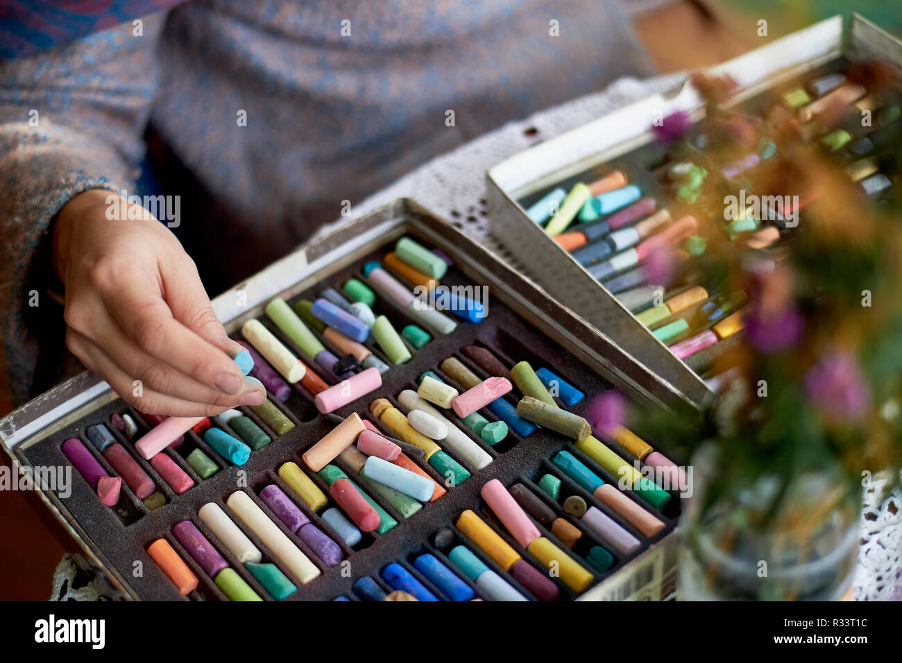 Box with pastel crayons and artist's hands.Drawing with dry pastel ...