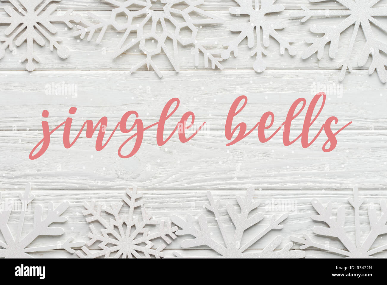 flat lay with decorative snowflakes on white wooden background with ...