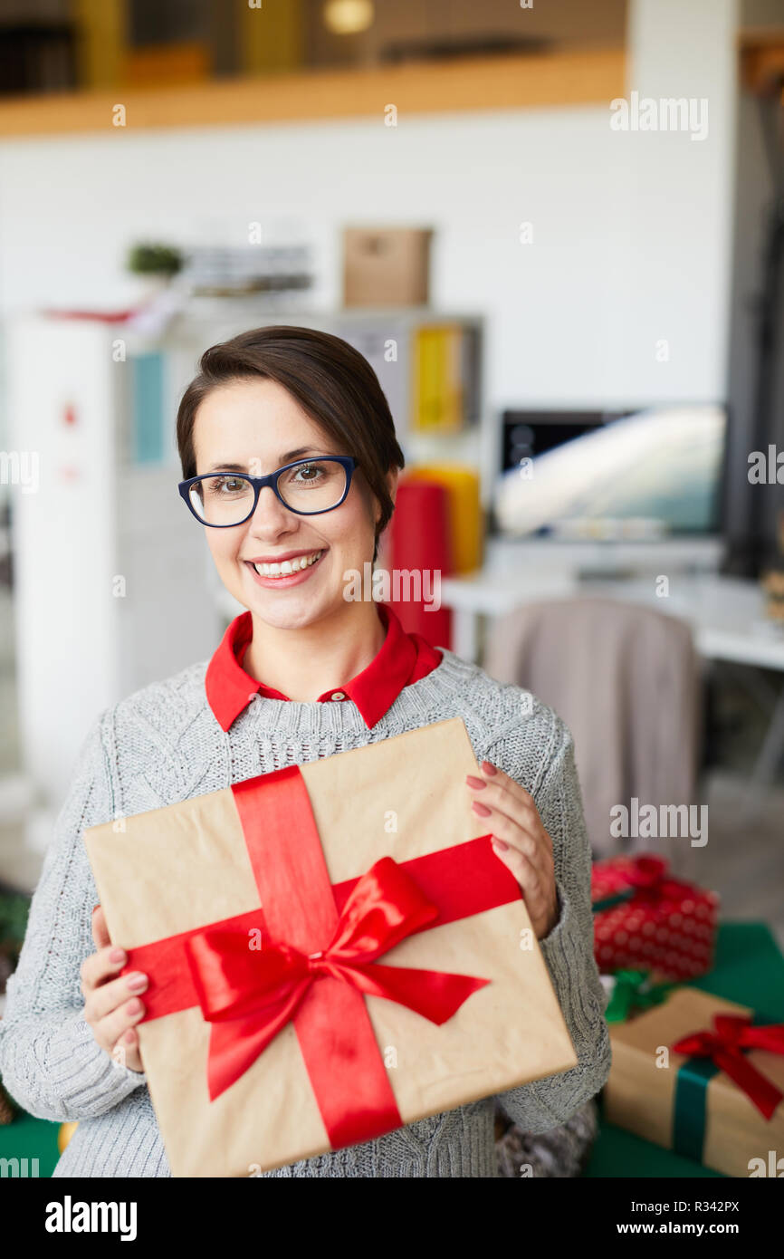 Young smiling female with packed box tied up with silk red ribbon ...