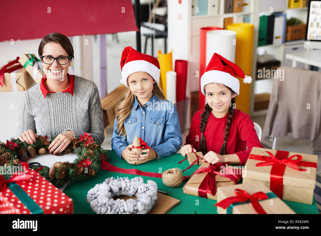 Happy little Santa girls and their pretty mother looking at you while ...