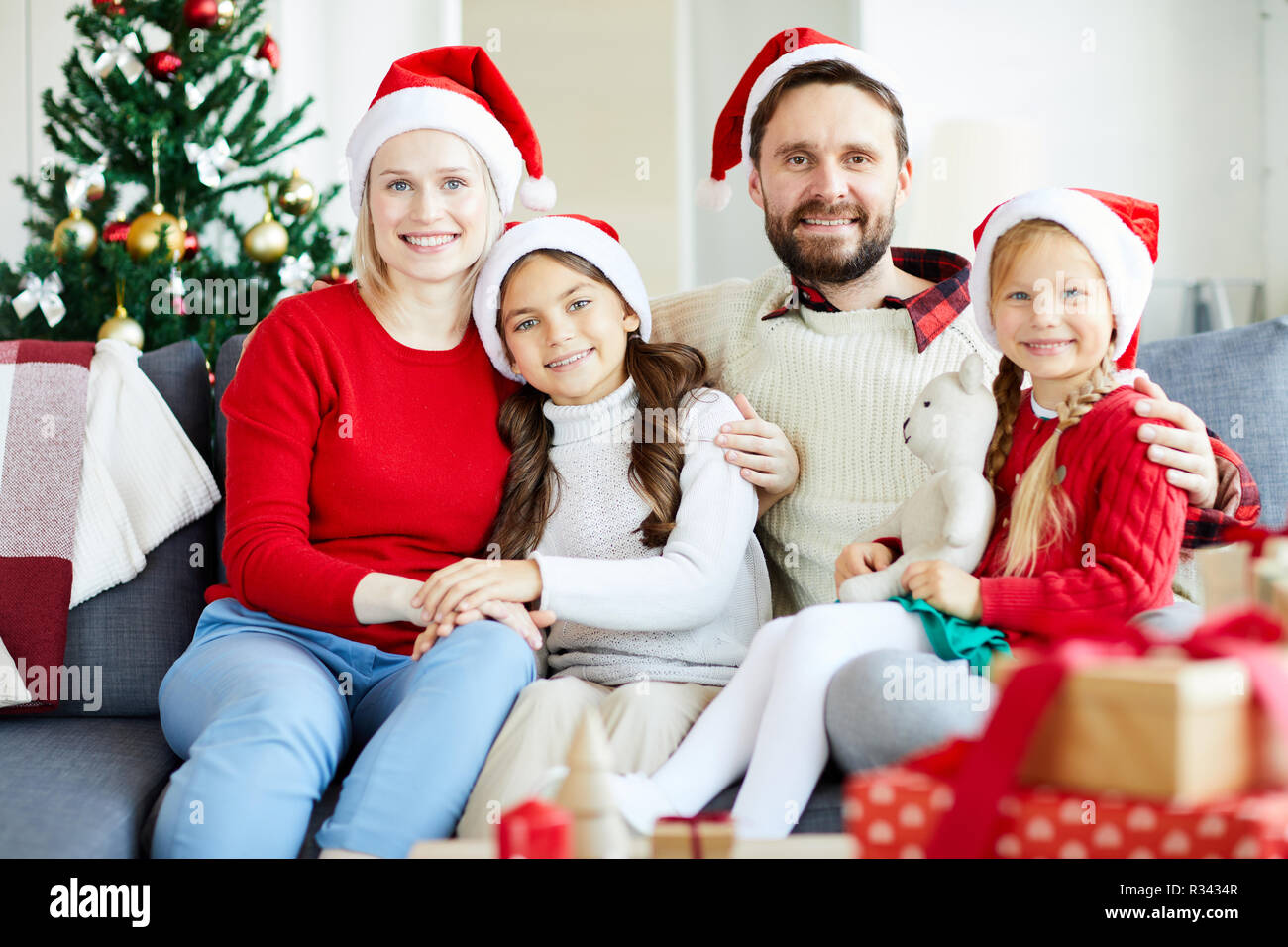 Happy young affectionate parents and their cute little daughters in ...