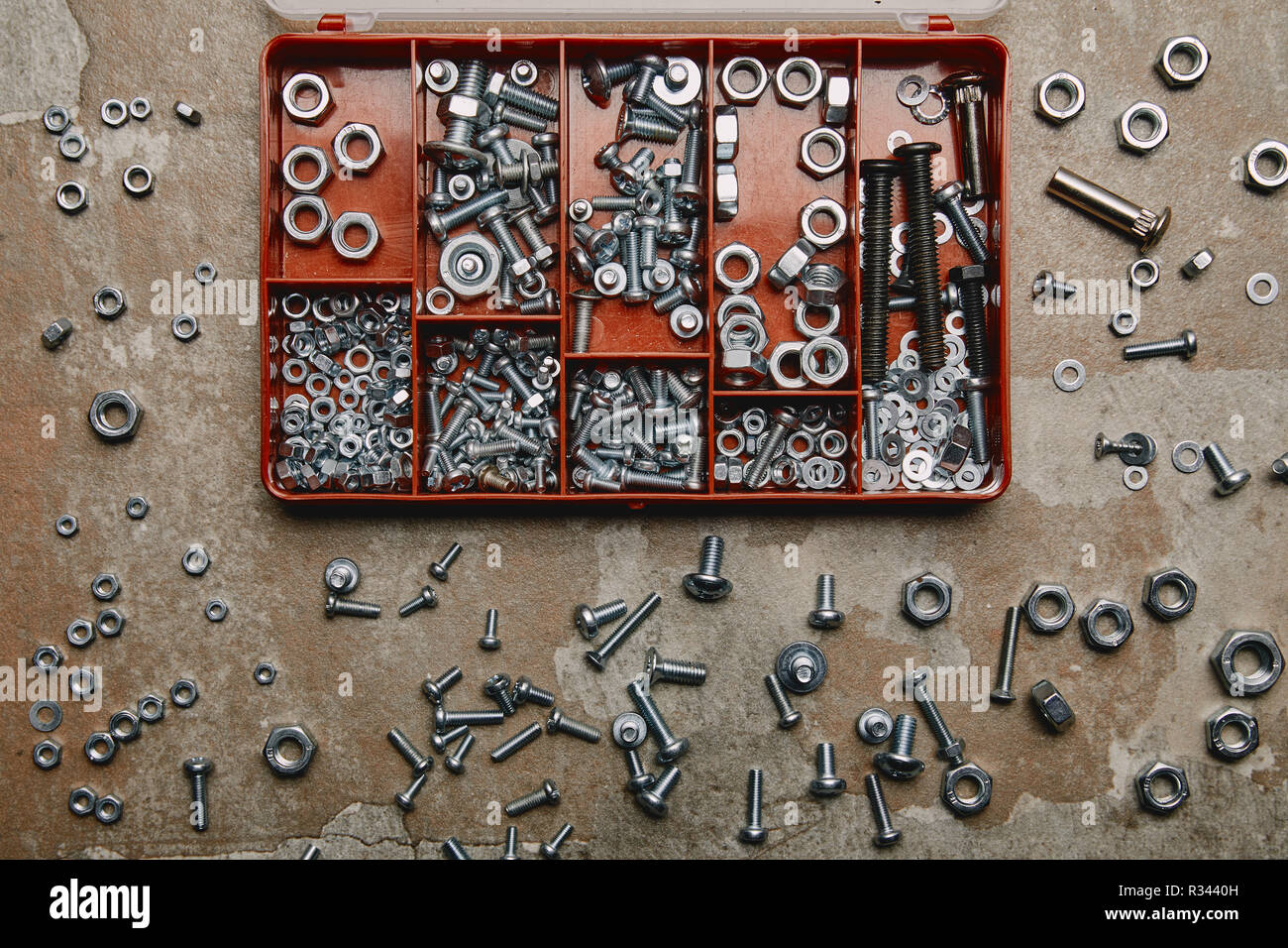 Top view of box with bolts and scattered nails and screws on old ...