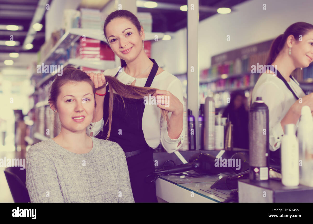 Young pleasant cheerful positive smiling female hairdresser with male ...