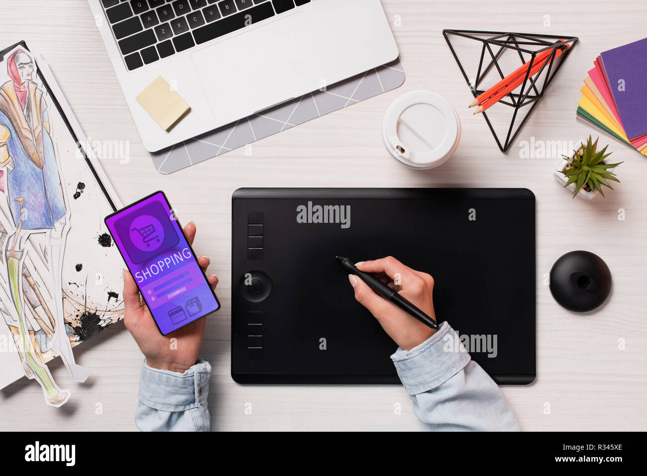 cropped view of designer hands using graphics tablet, pen and ...