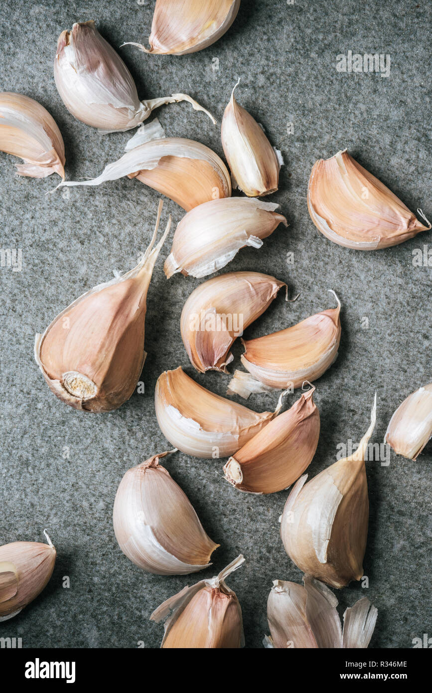 top view of ripe garlic cloves with husk on grey background Stock Photo ...