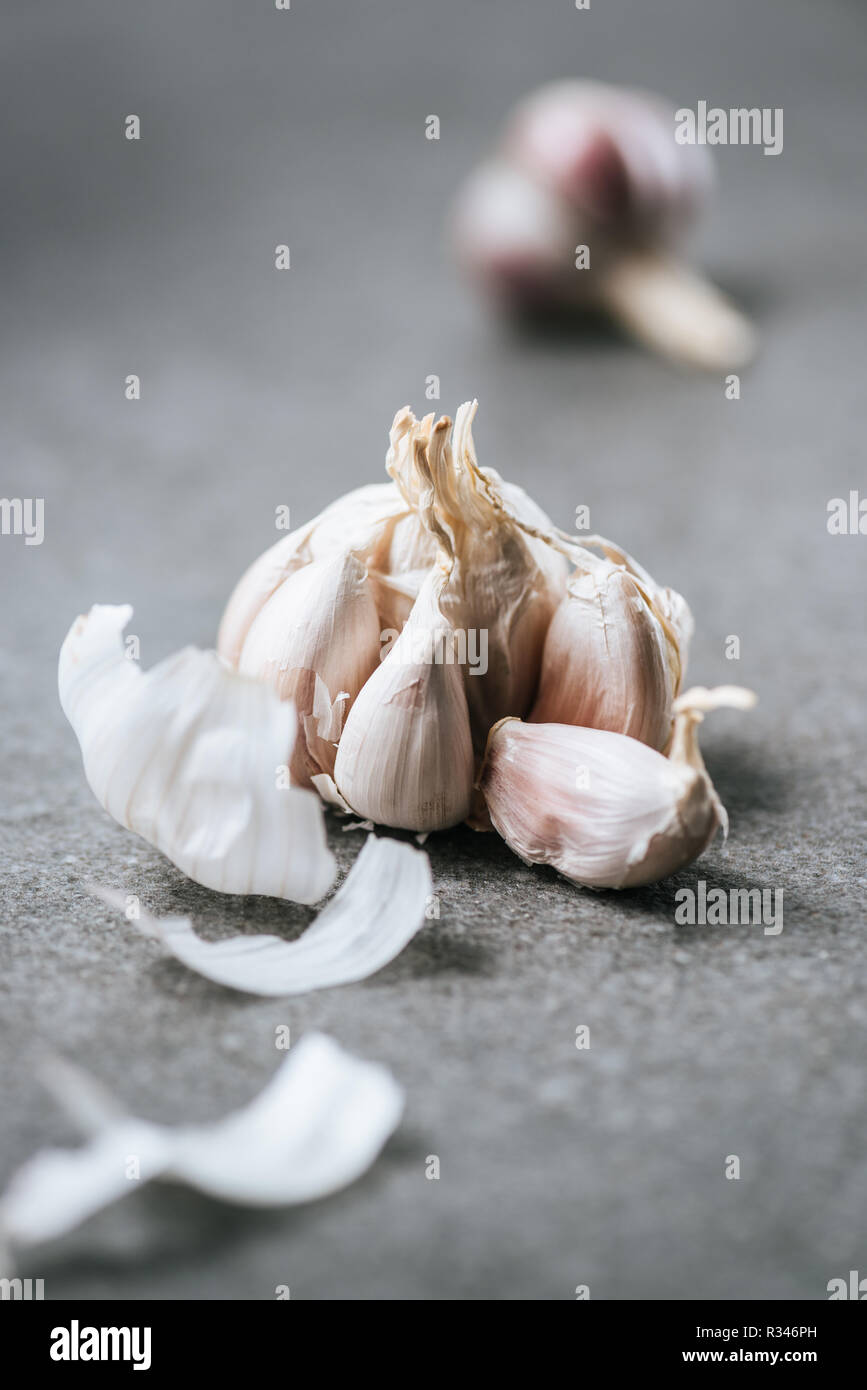 peeled bulb of garlic with husk on grey marble table Stock Photo - Alamy