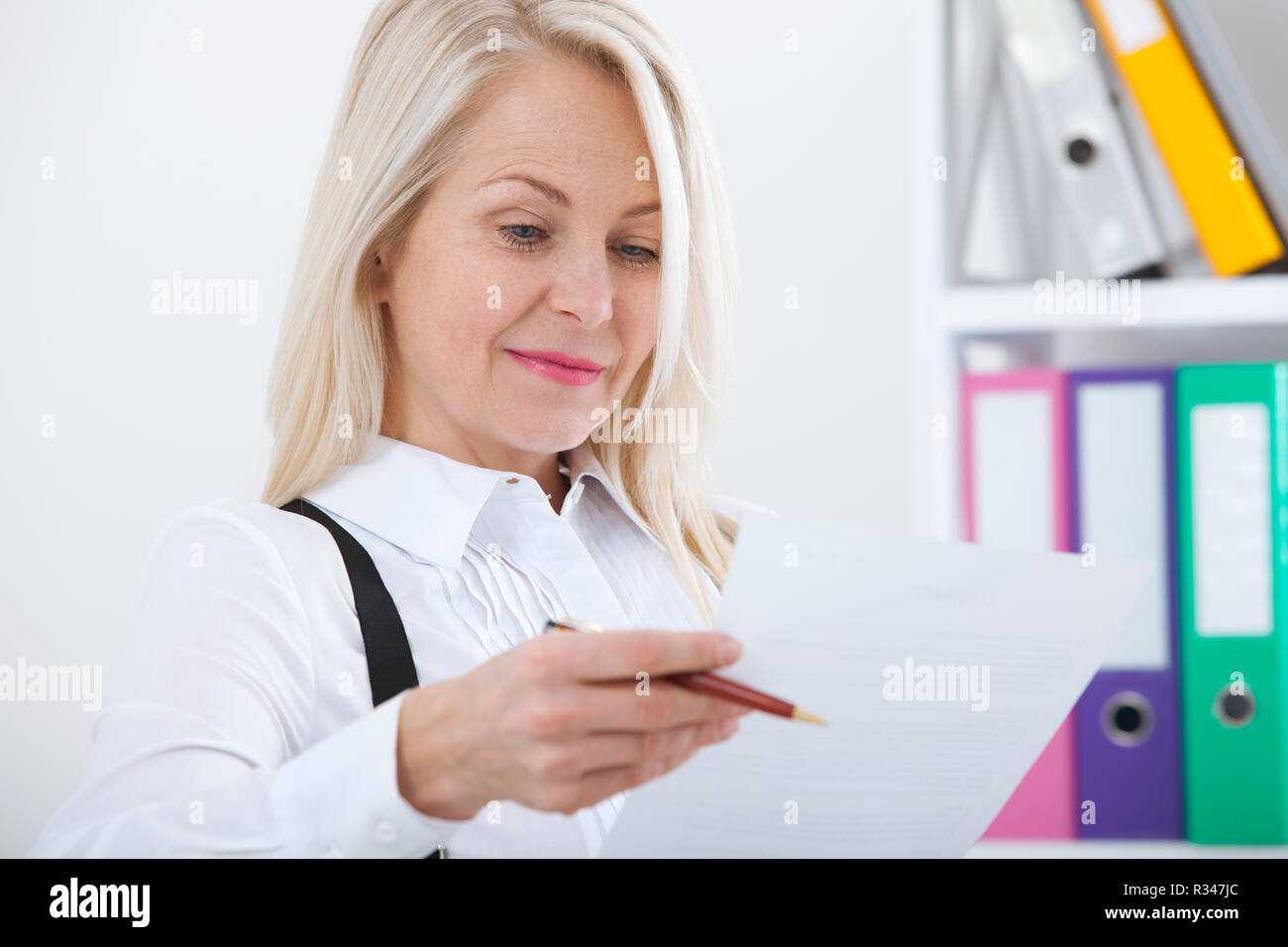 Happy business woman working in office with documents. Woman reading ...