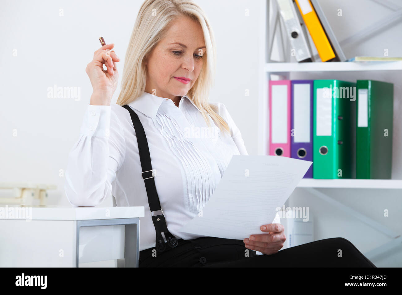 Happy business woman working in office with documents. Woman reading ...