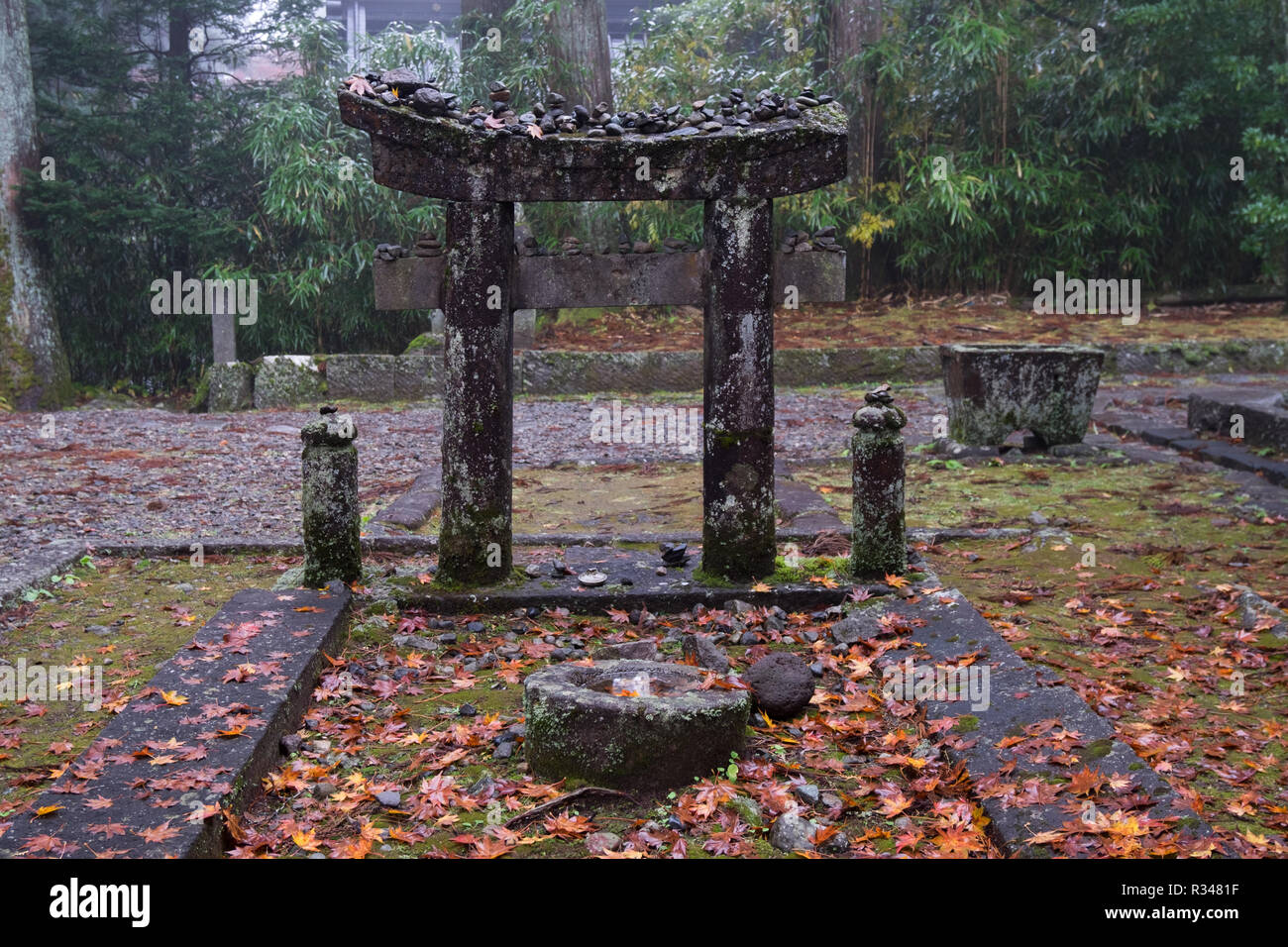 A stone Japanese gate at Shihonryuji with rocks placed along the top of ...