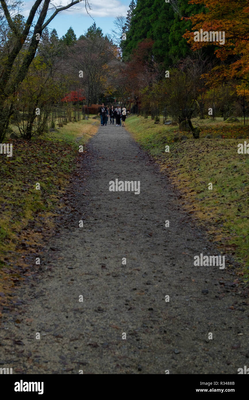 People walking along a gravel path in Ganman stone park in Nikko, Japan ...