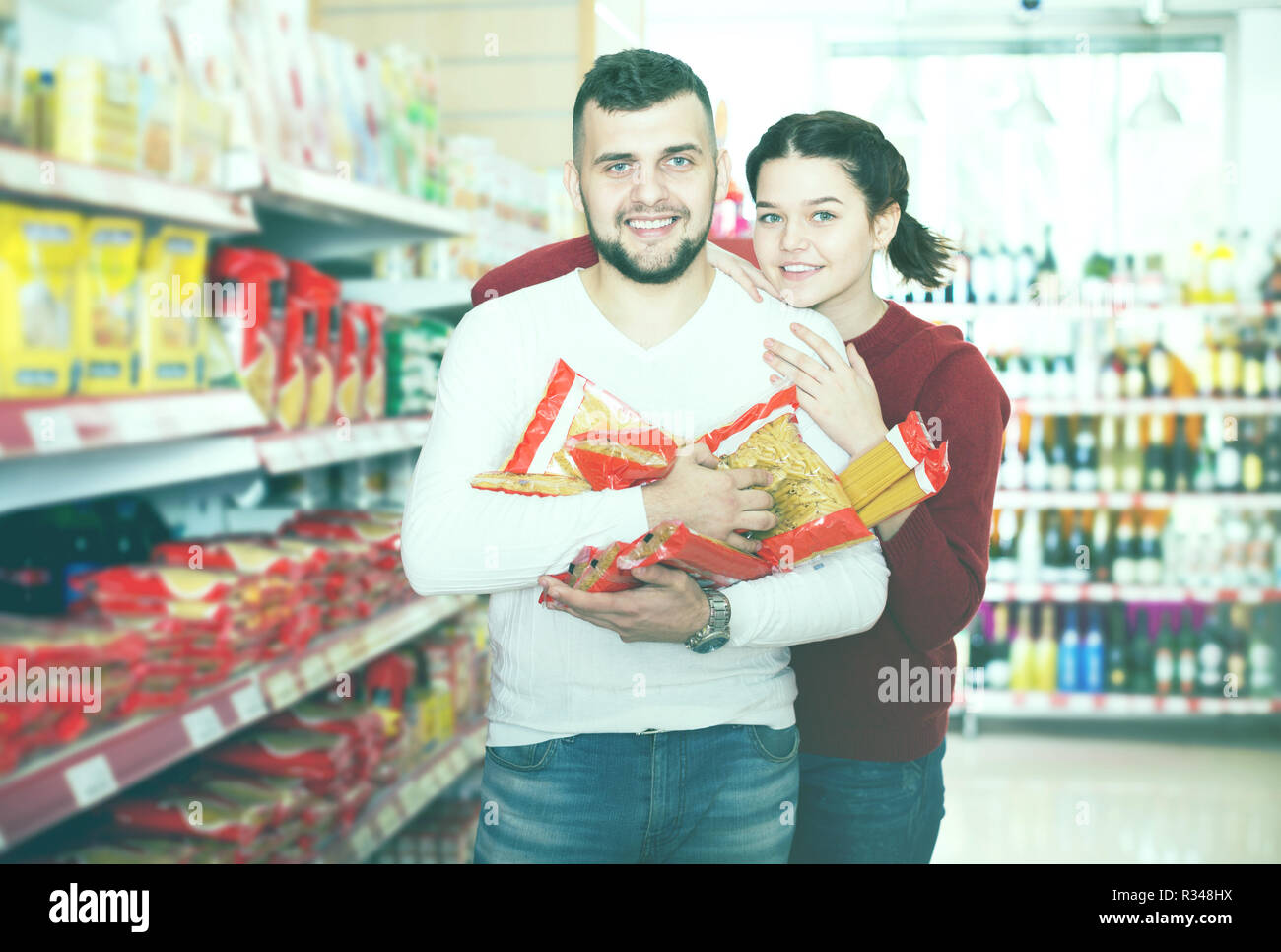 Positive adults reading lable of pasta at supermarket Stock Photo - Alamy